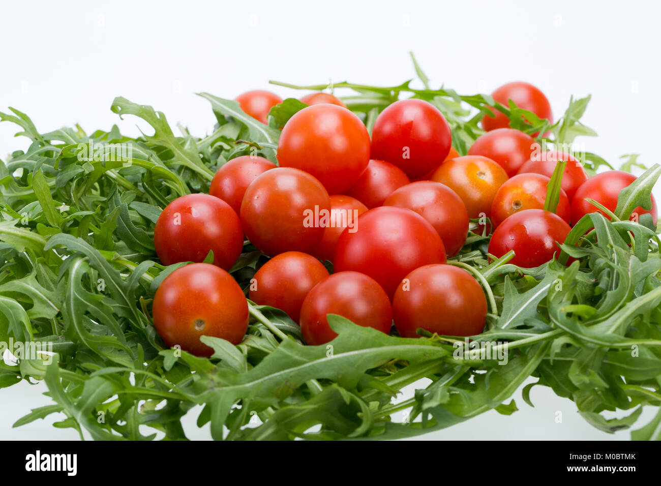 Heap of ruccola leaves and cherry tomatoes Stock Photo - Alamy
