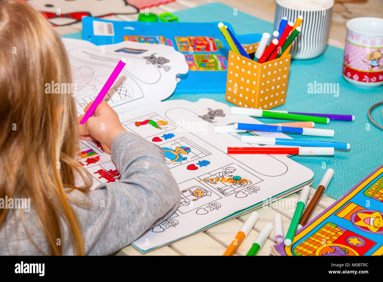Closeup of girl drawing with colorful pencils in coloring book Stock ...