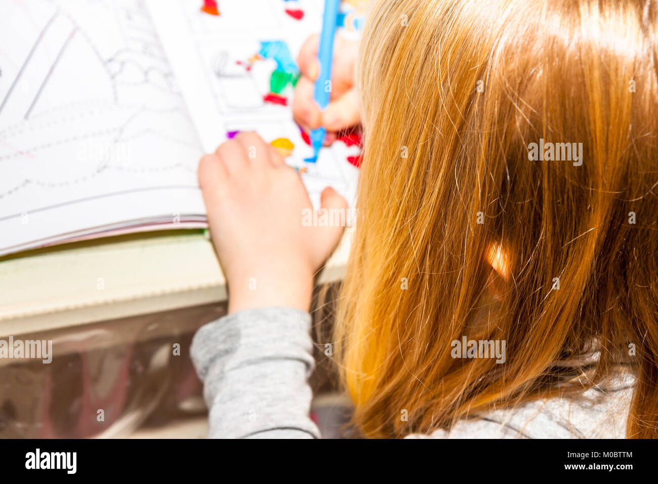 Closeup of girl drawing with colorful pencils in coloring book Stock ...