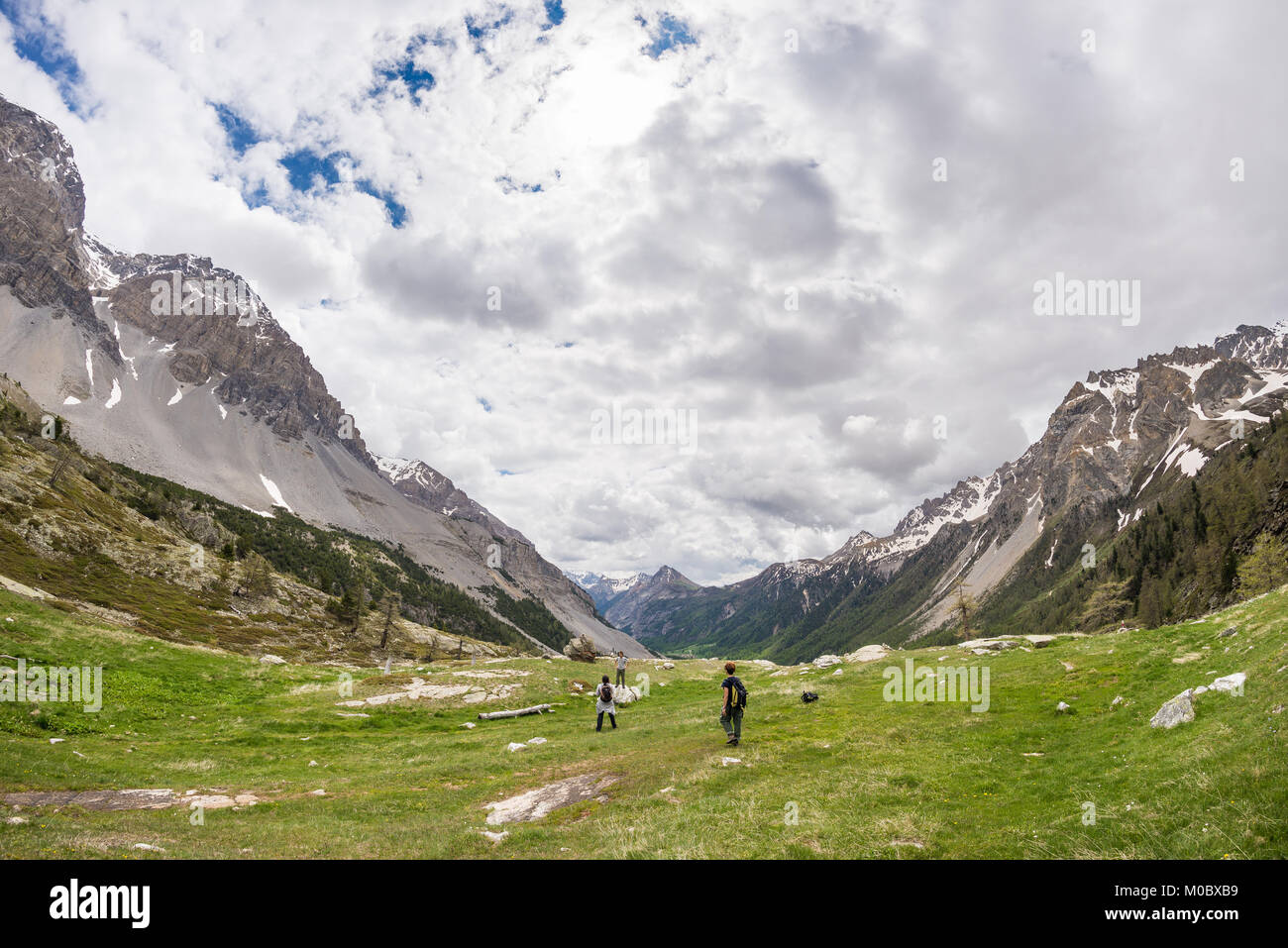 Hikers climbing uphill on steep rocky mountain trail. Summer adventures ...