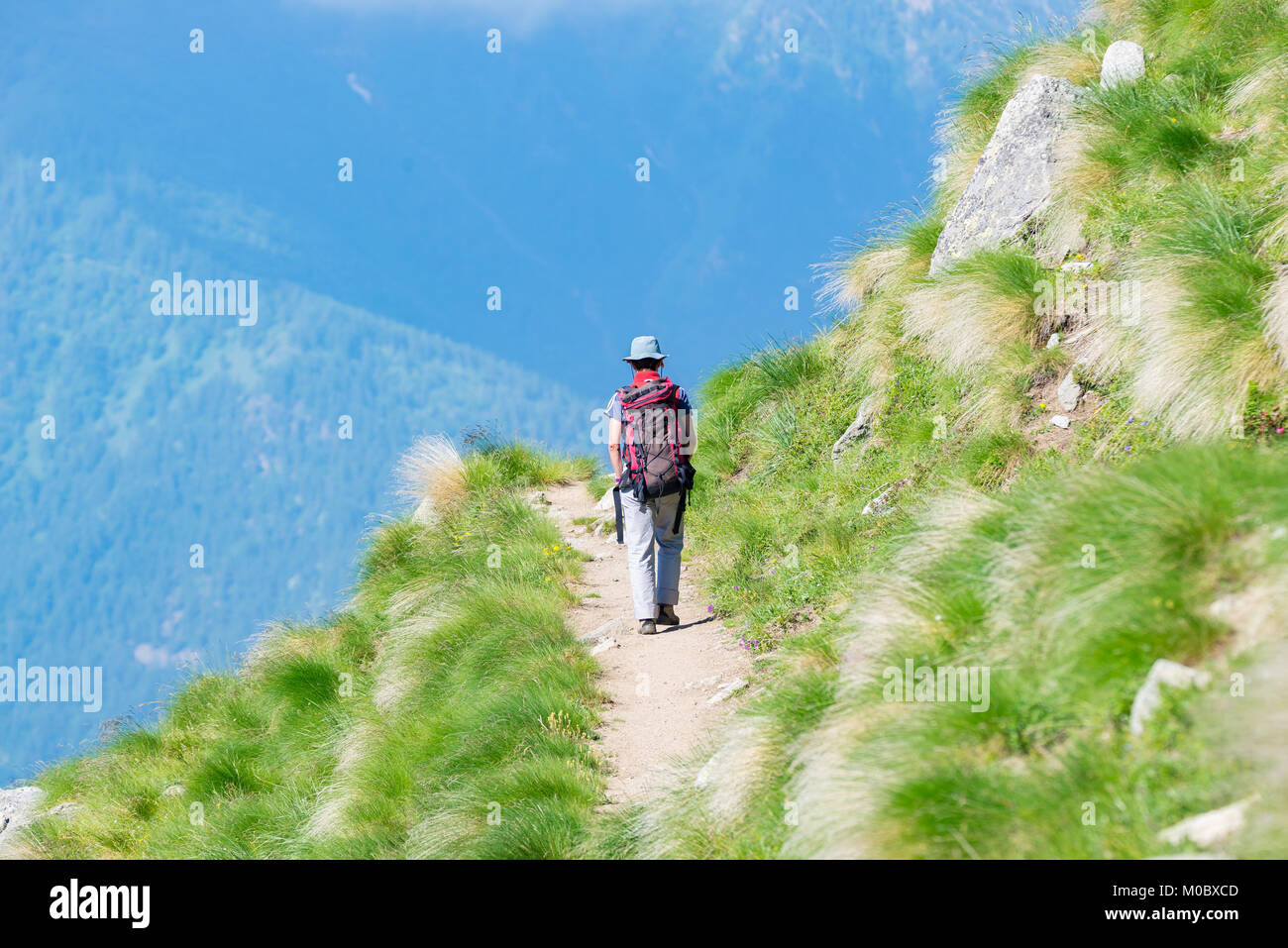 Backpacker walking on hiking trail in the mountain. Summer adventures ...