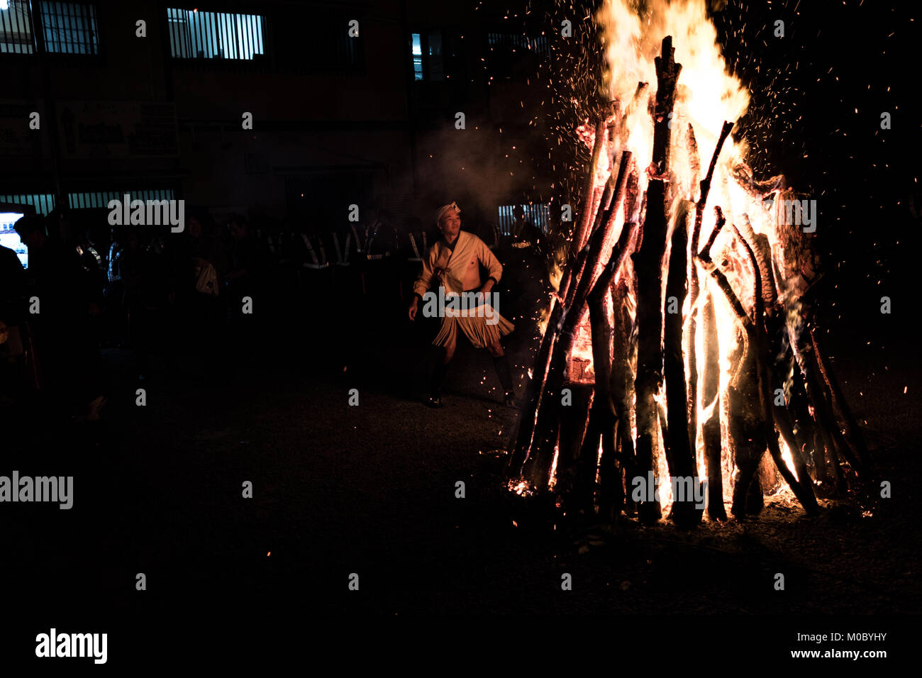 A man tending to huge bonfire at Kurama fire festival, Mount Kurama ...