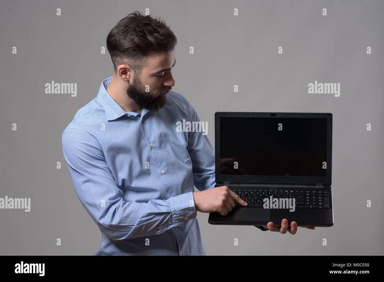 Young confident business man or programmer using computer and watching ...
