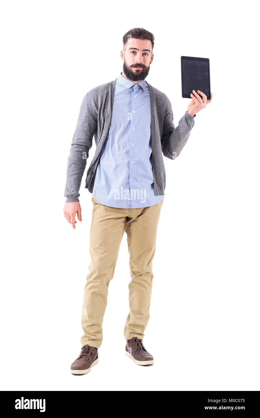 Uncertain skeptical young bearded man holding and showing pad tablet ...