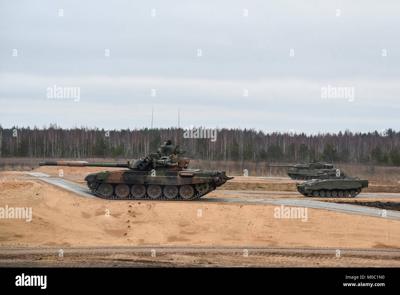 Polish soldiers, left, and Spanish soldiers and their vehicles test a ...
