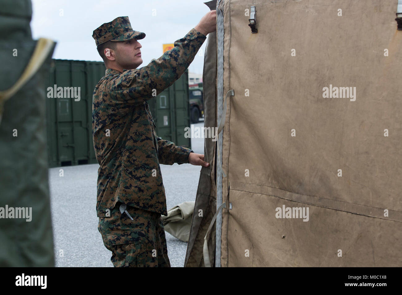 CAMP FOSTER, OKINAWA, Japan – Lance Cpl. Abdul Zhaiya secures the cover ...