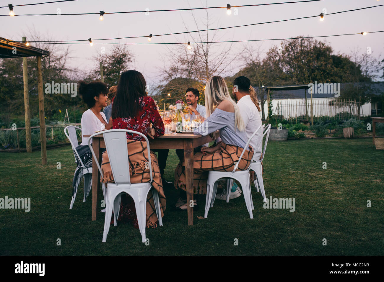 Group of friends sitting at outdoors restaurant and having dinner ...