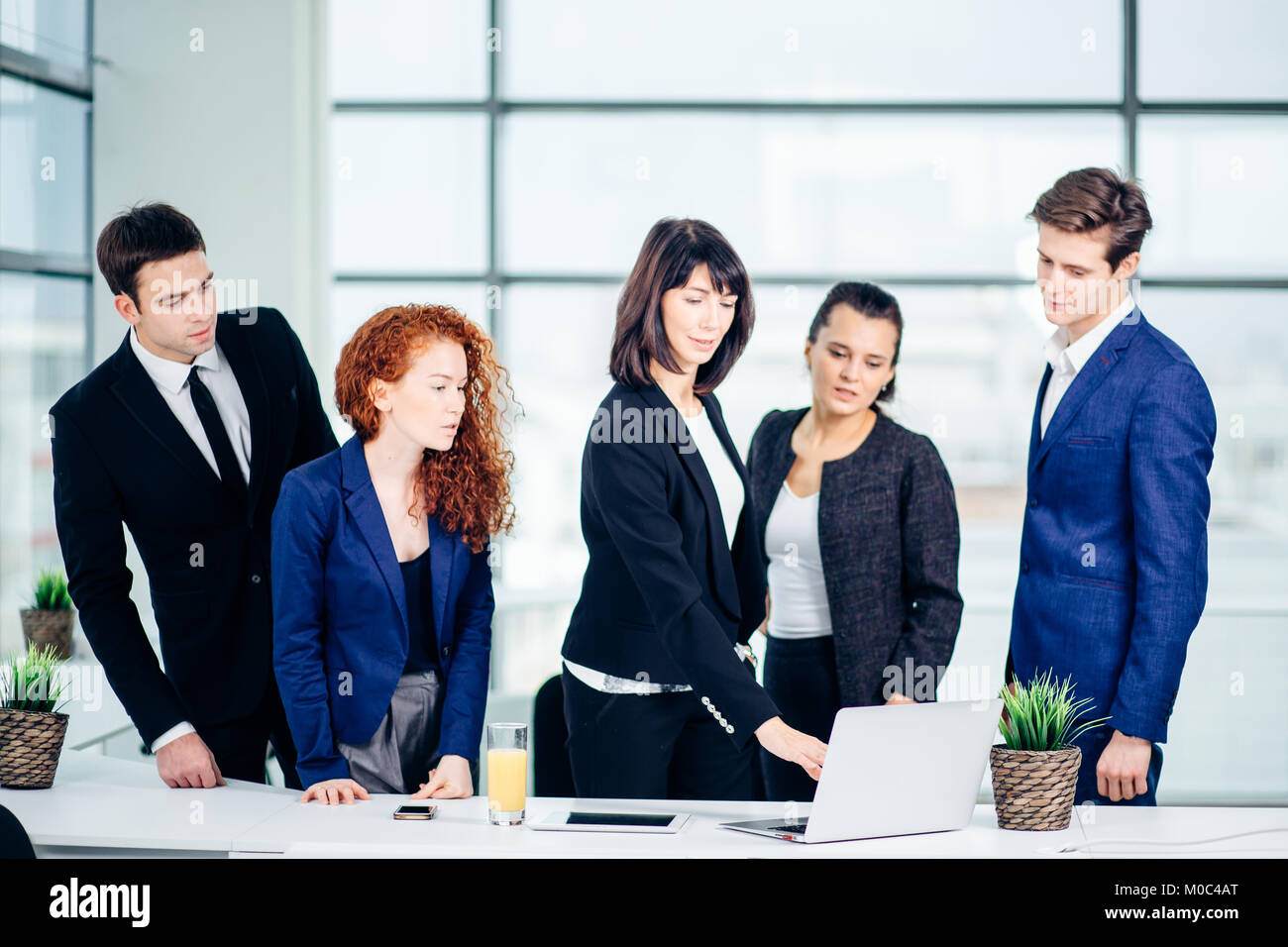 male and female business people around laptop computer in office Stock ...