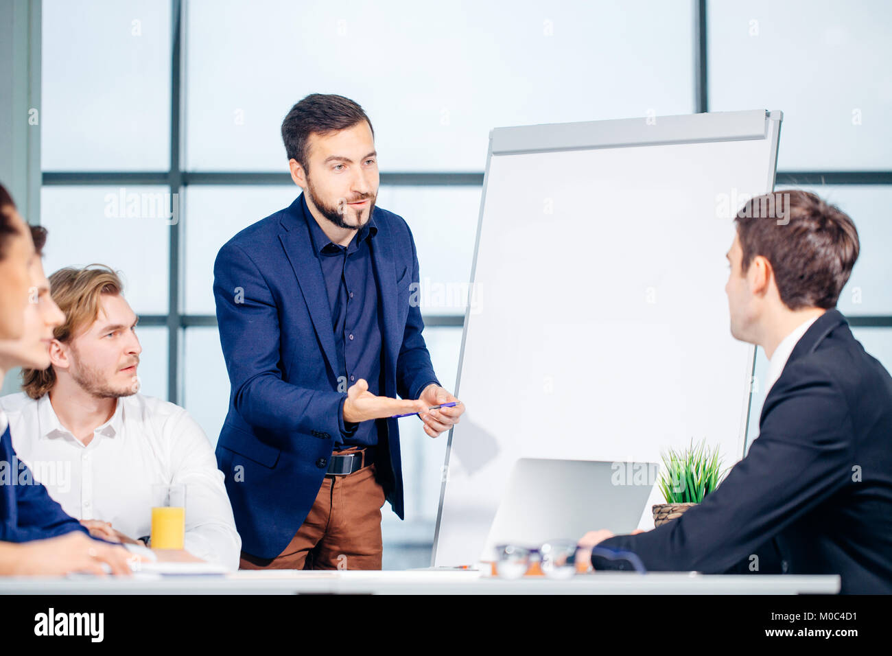 Businessman presenting to colleagues at meeting Stock Photo - Alamy
