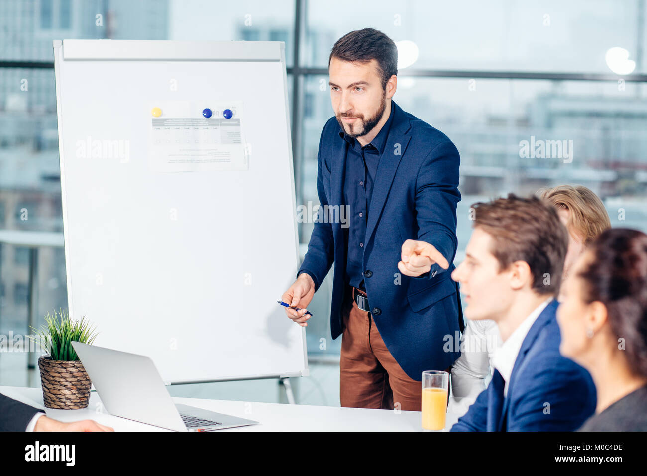 smiling male boss talking to business group Stock Photo - Alamy