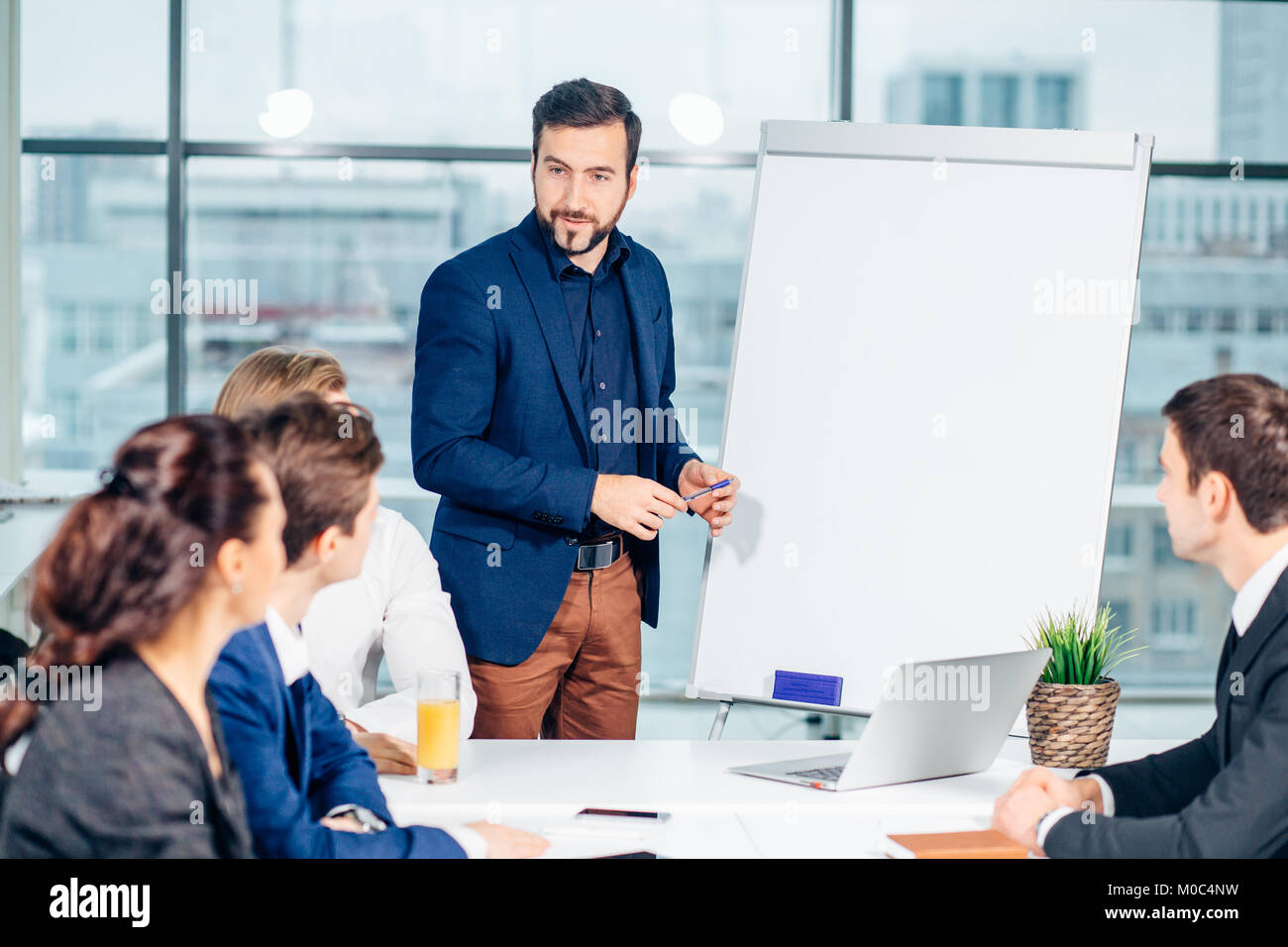 Group of business people looking at graph on flipchart Stock Photo - Alamy