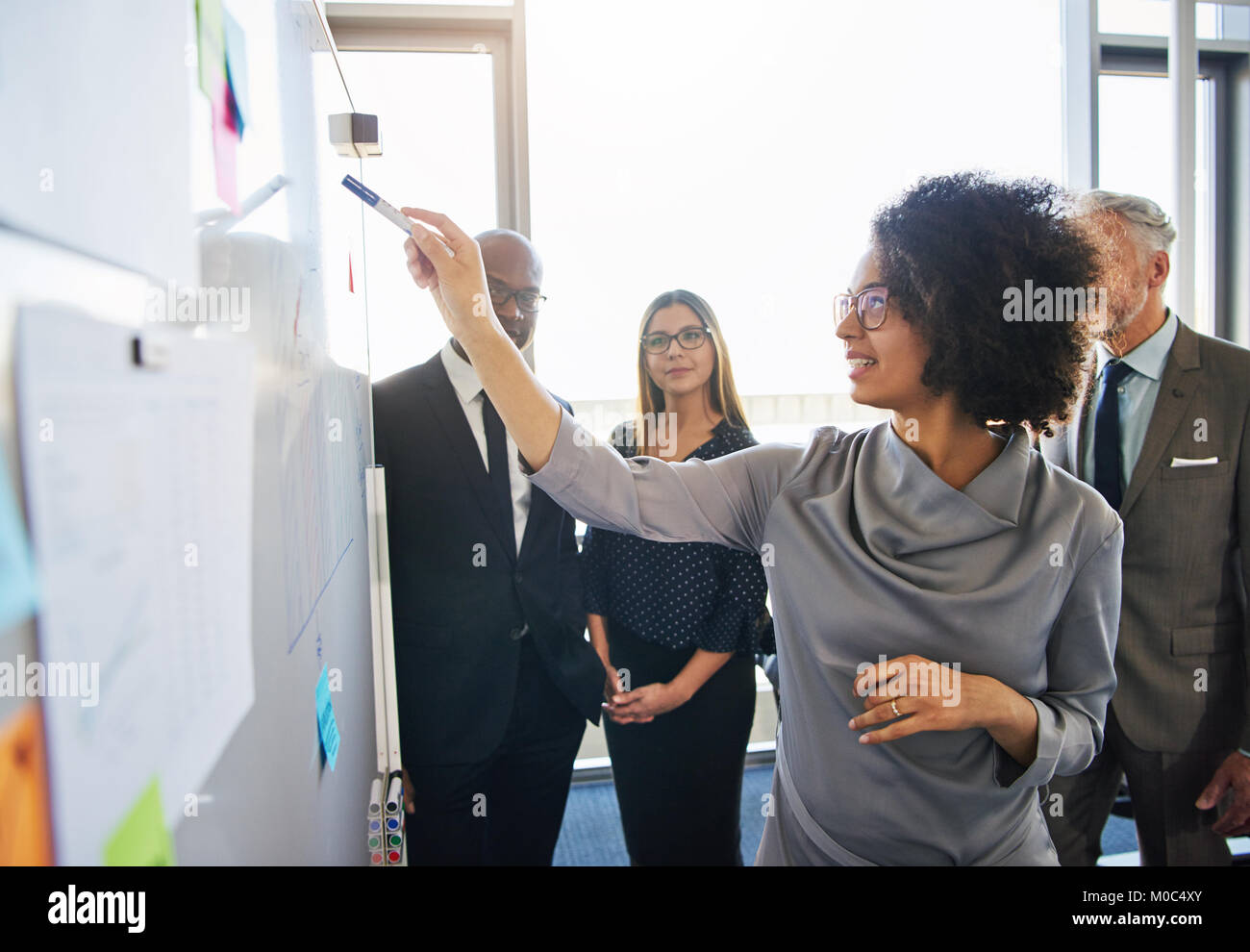 Diverse group of focused businesspeople brainstorming together on a ...