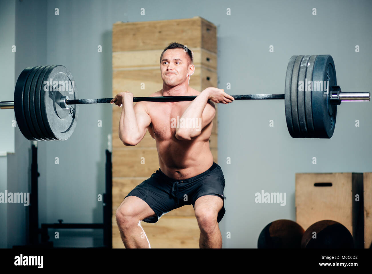 Athlete wearing black shorts lifting big barbell Stock Photo - Alamy