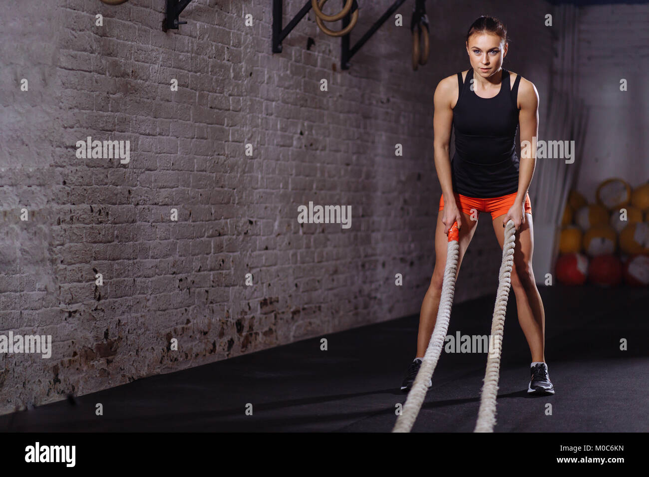woman preparing to working out with battle ropes in cross fit gym Stock ...