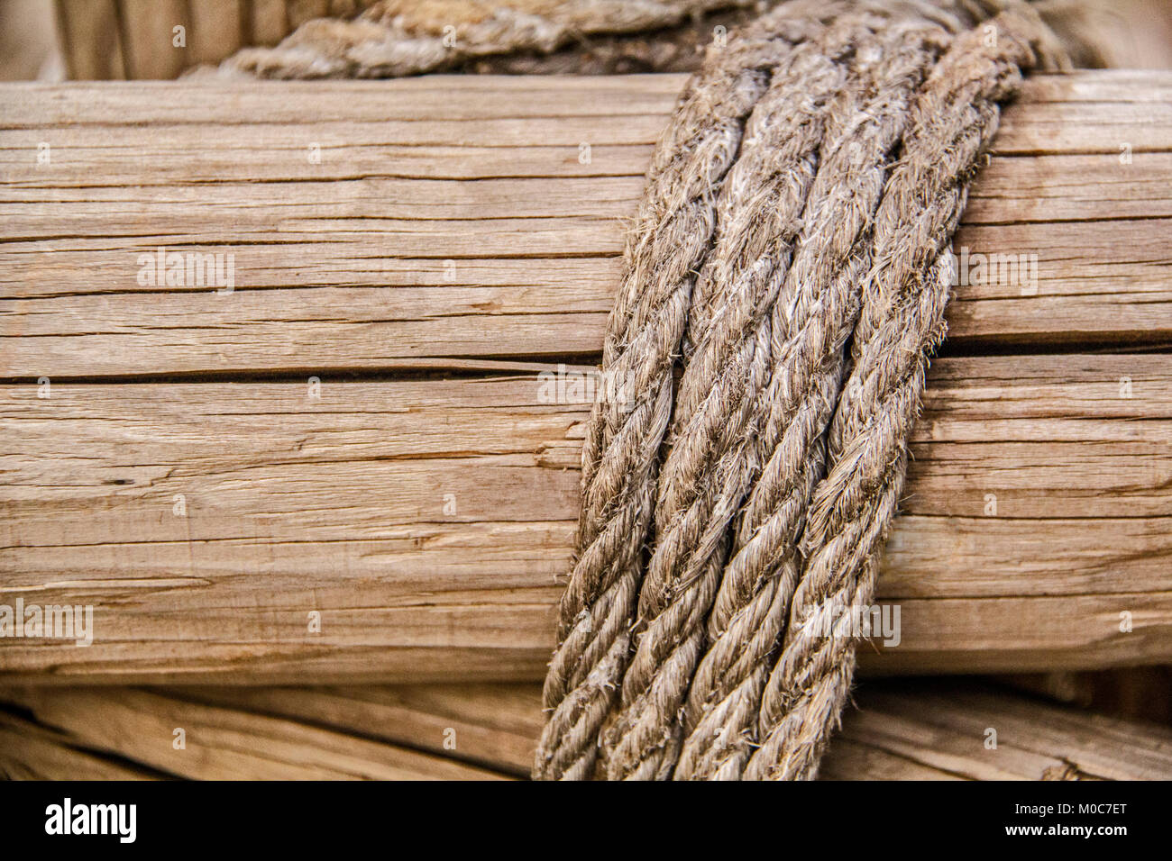 Close up of Aged rope on old weathered rustic wooden bulk background ...