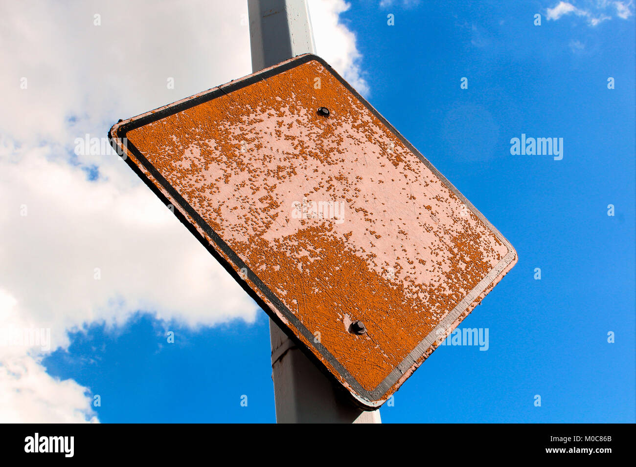 A blank orange peeling sign against a blue sky Stock Photo - Alamy