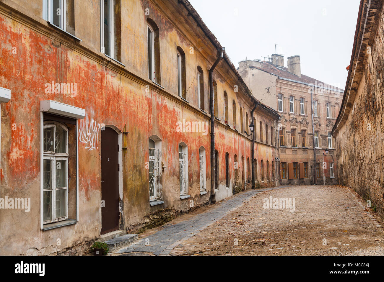 Dilapidated, run-down side street of empty old terraced houses with ...