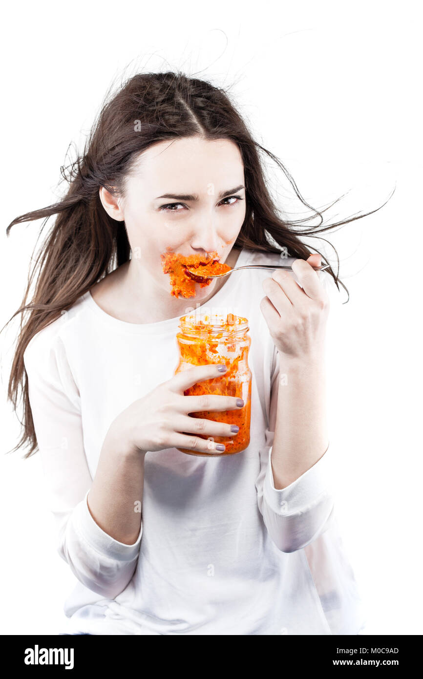 girl eating ajvar, roasted red pepper and eggplant from a jar, getting ...