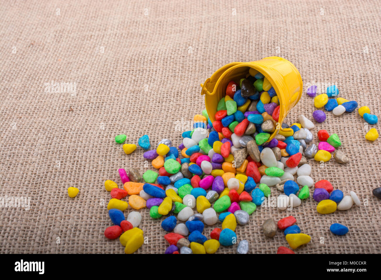 Bucket of colorful pebbles spill on background Stock Photo - Alamy