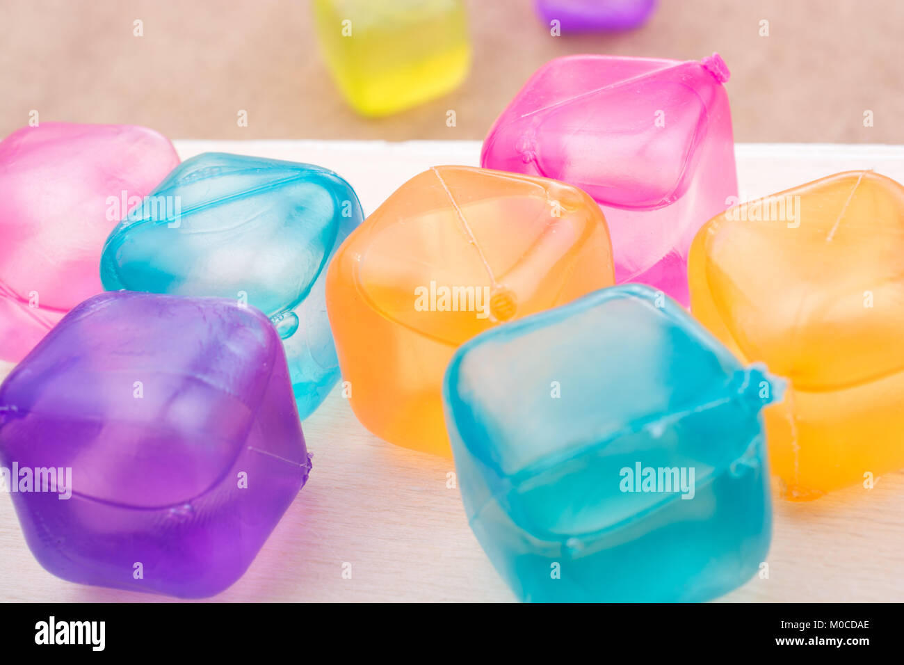 Fake colorful ice cubes on a brown background Stock Photo - Alamy