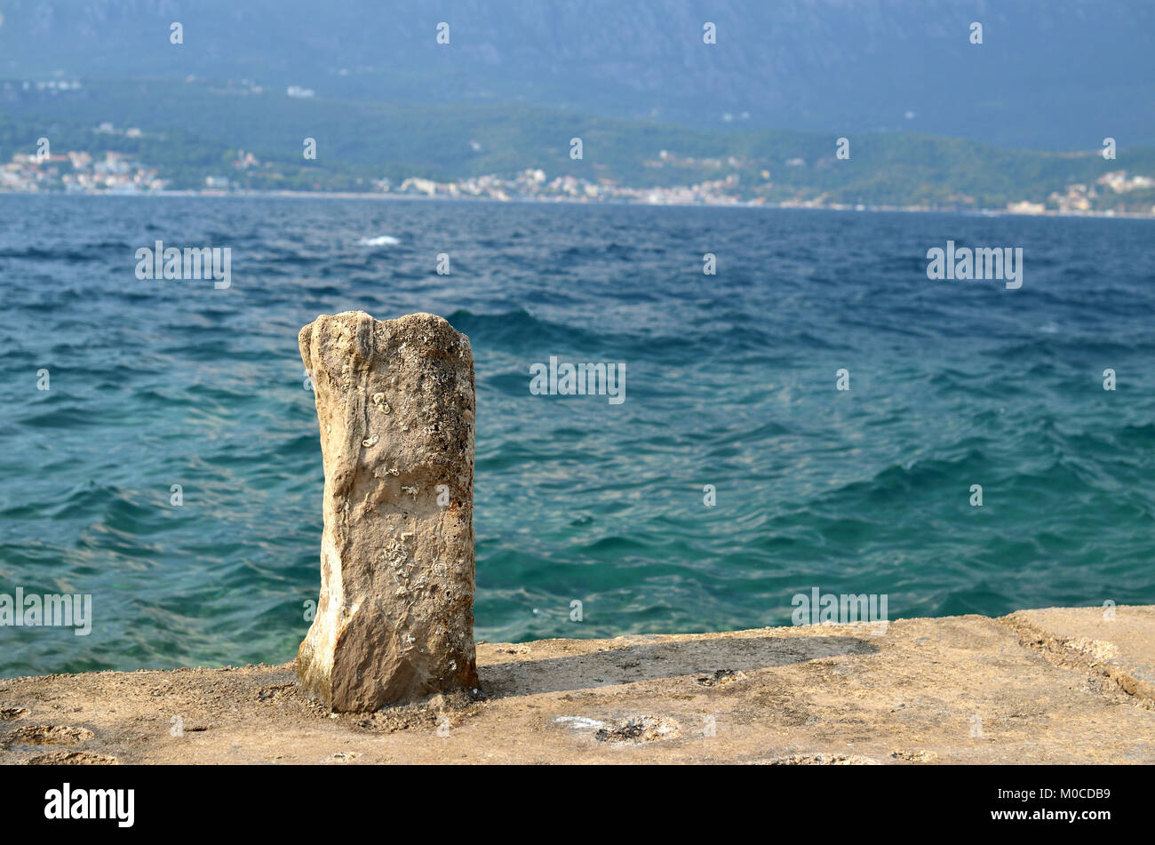 Old stone on a dock for binding boats and blue sea Stock Photo - Alamy