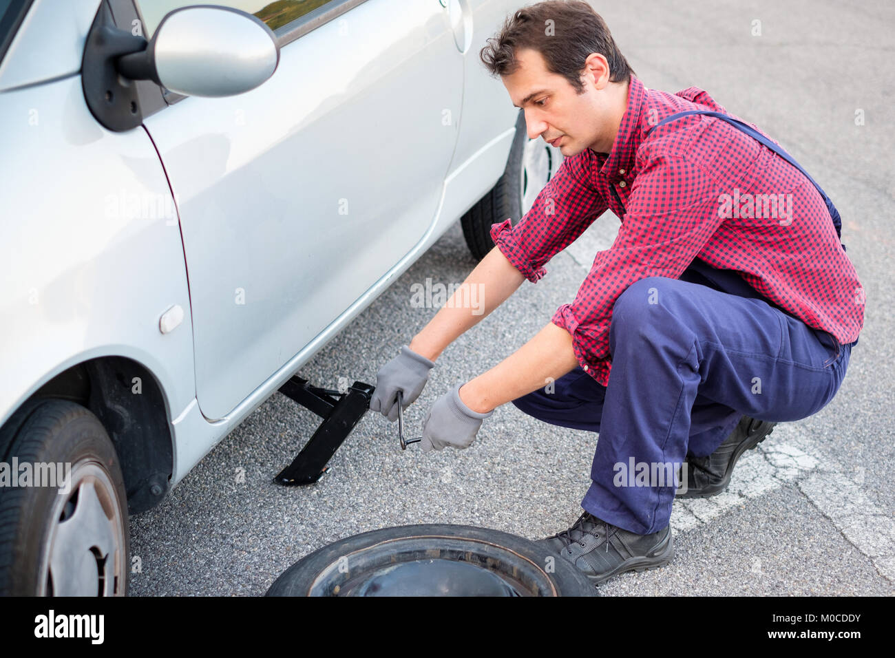 Person changing flat tire hi-res stock photography and images - Alamy
