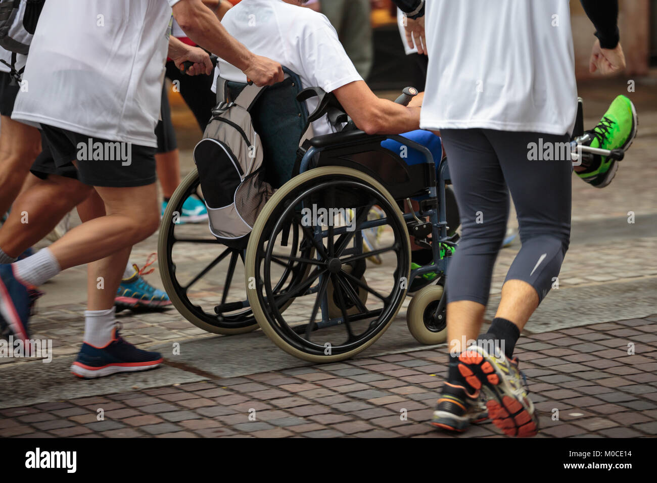 Disabled Athlete in a Sport Wheelchair during Marathon Helped by ...
