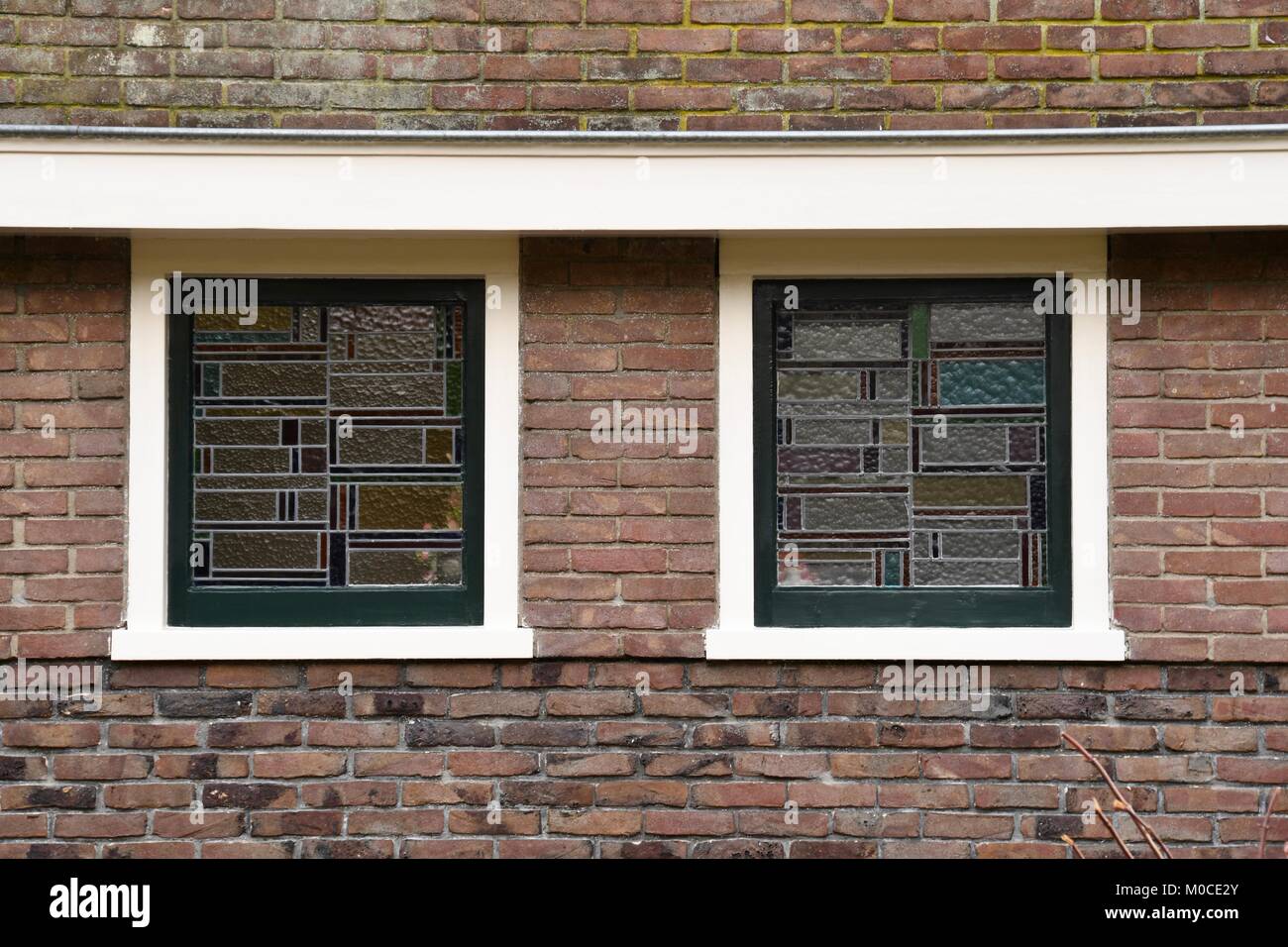Stain glass windows in red brick wall Stock Photo - Alamy