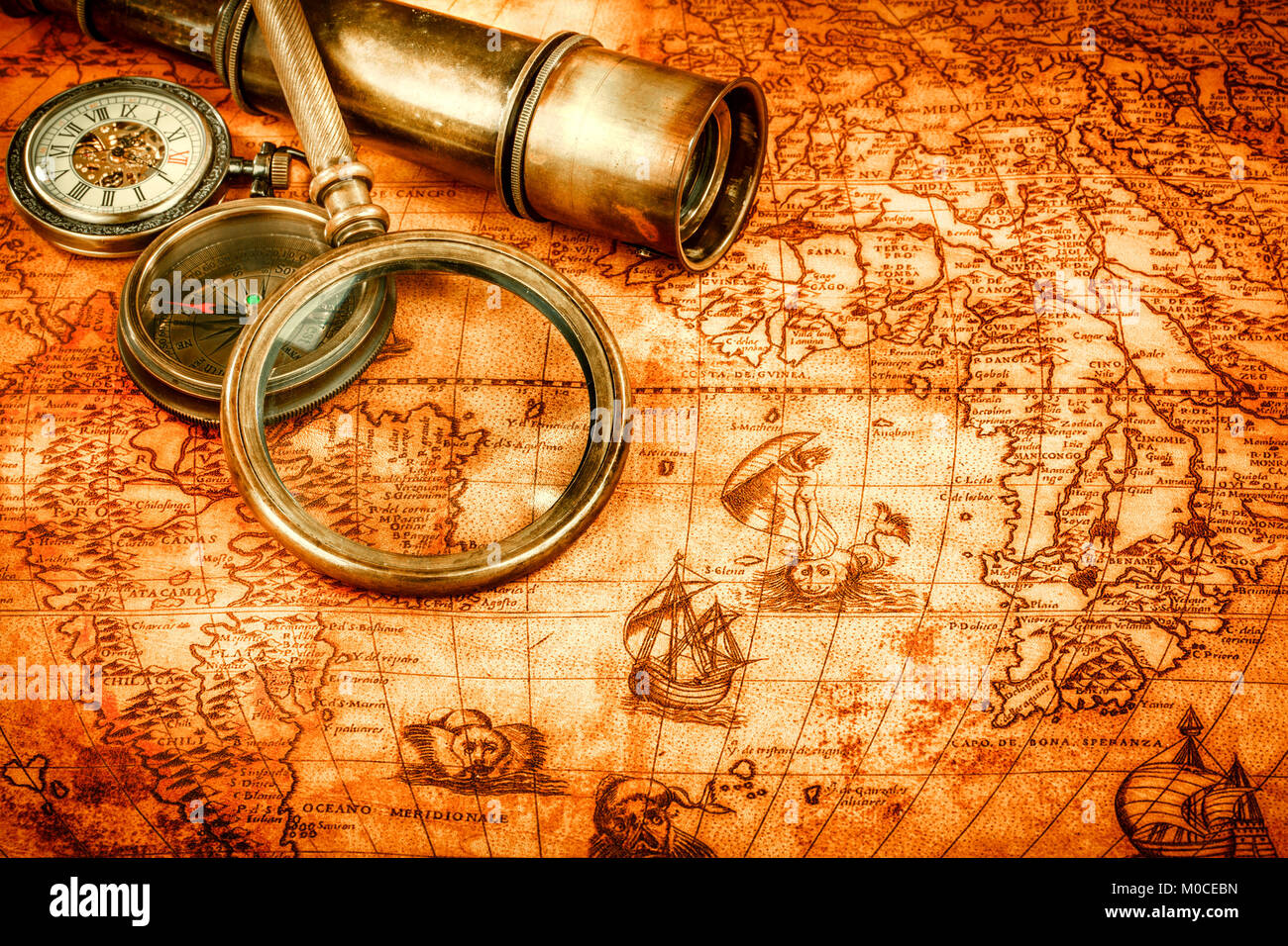 Vintage compass, magnifying glass, pocket watch, quill pen on an old ...