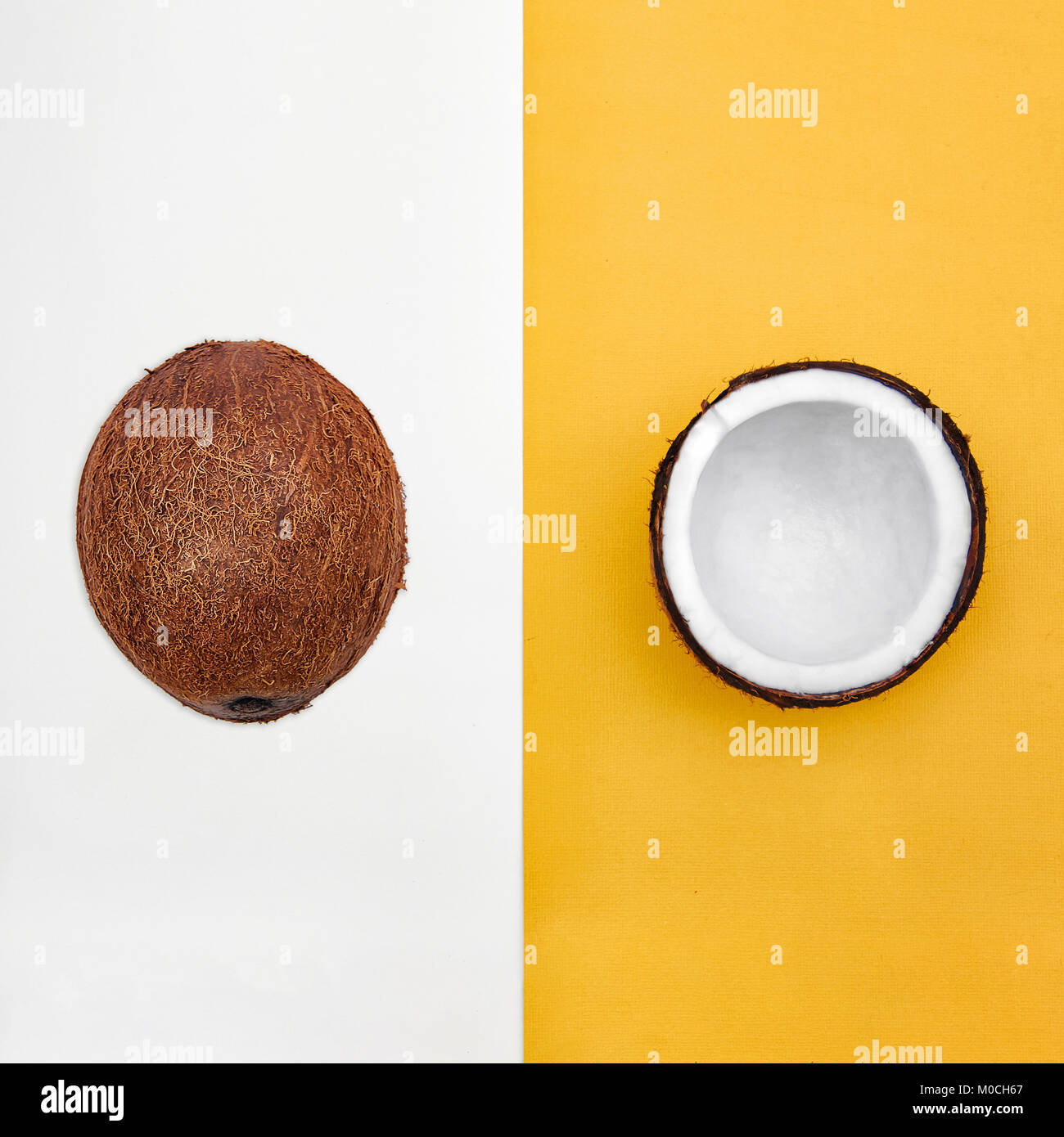 Whole coconut in peel and half of coconut are lying on two-tone ...