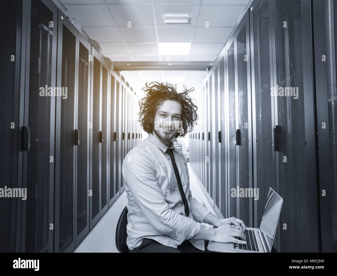 Male IT engineer working on a laptop in server room at modern data ...