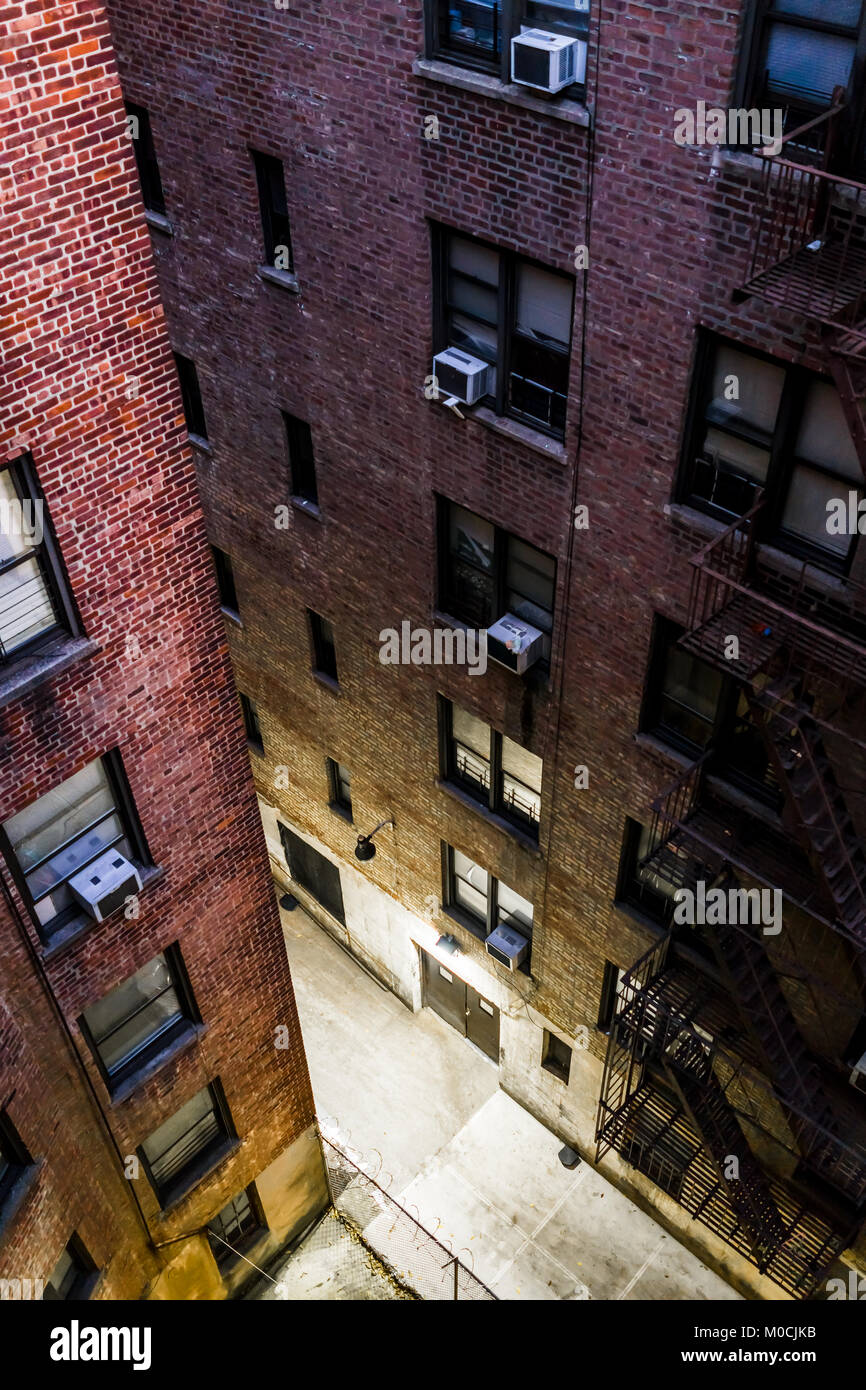 Aerial view down of illuminated brick apartment condo building ...