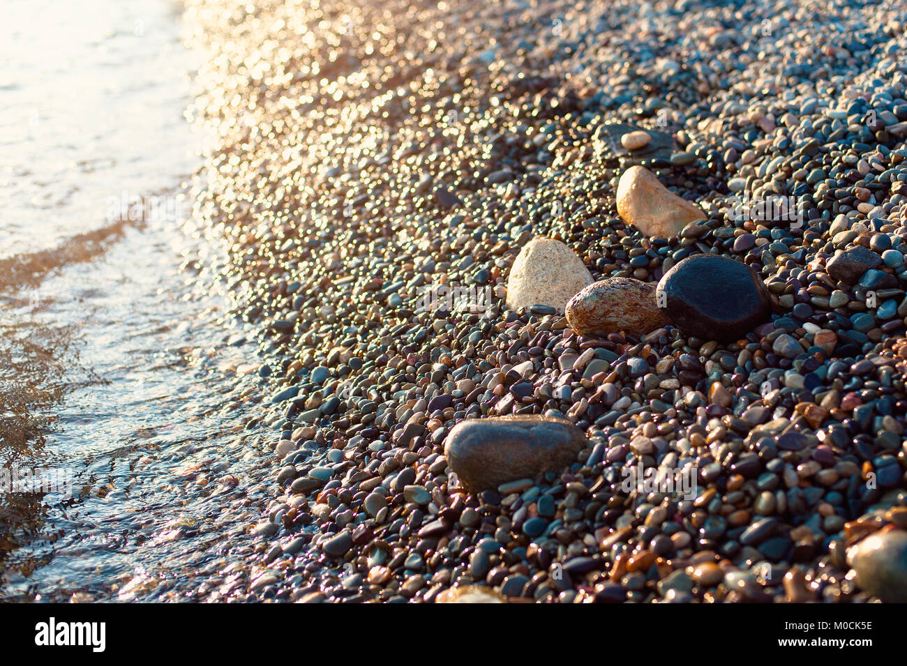 Stones on beach and sea water Stock Photo - Alamy