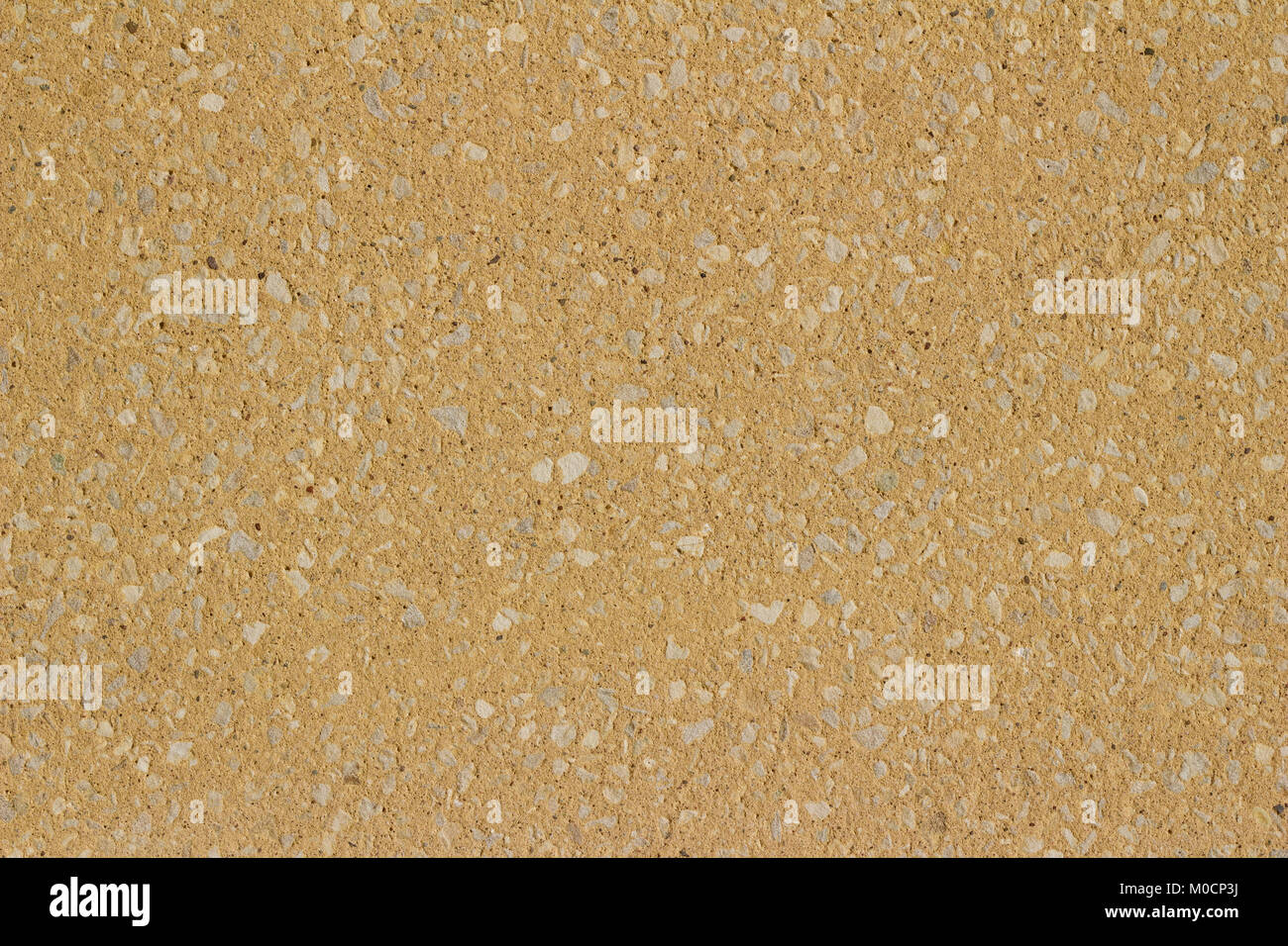 Sand colored tan stucco wall background with exposed stones on its ...