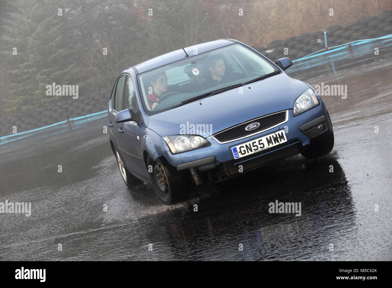 A young driver is given instruction on how to control a car during ...