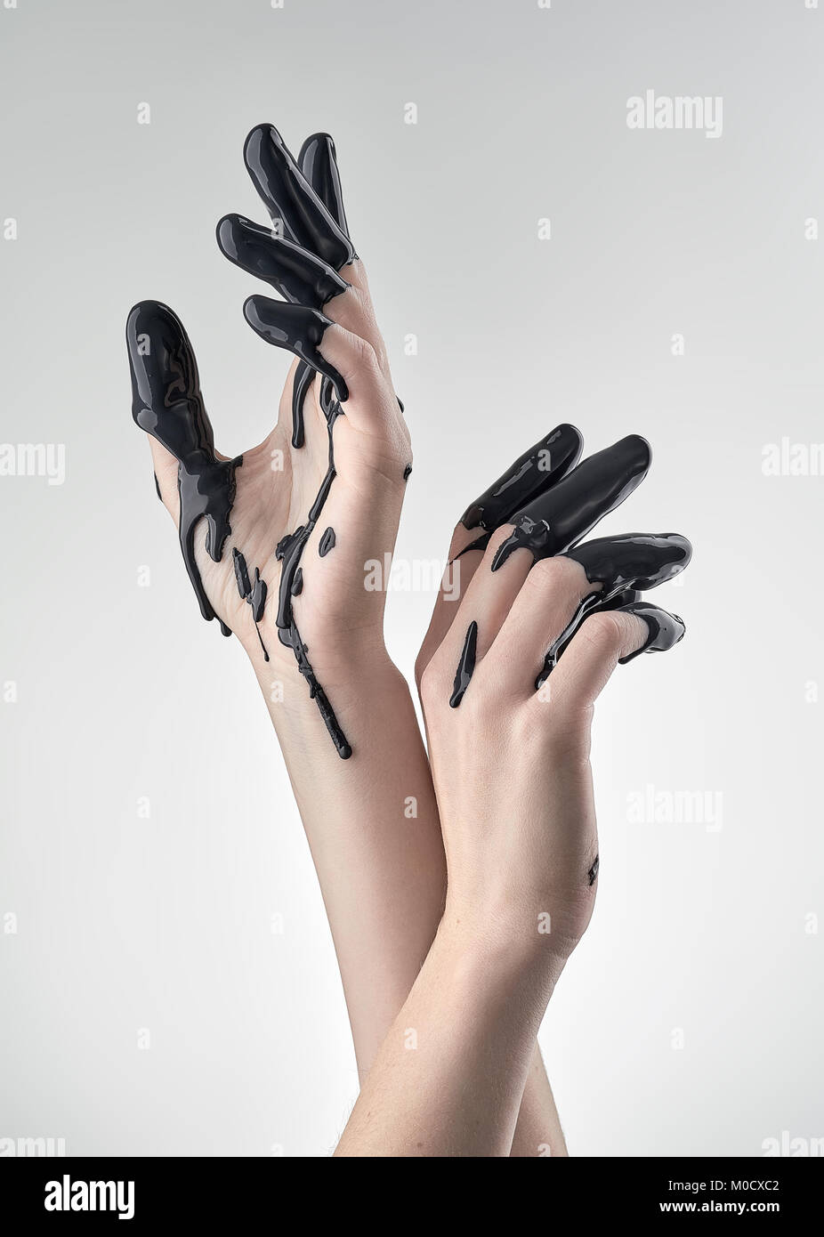 Female hand in liquid black oil or paint Stock Photo - Alamy