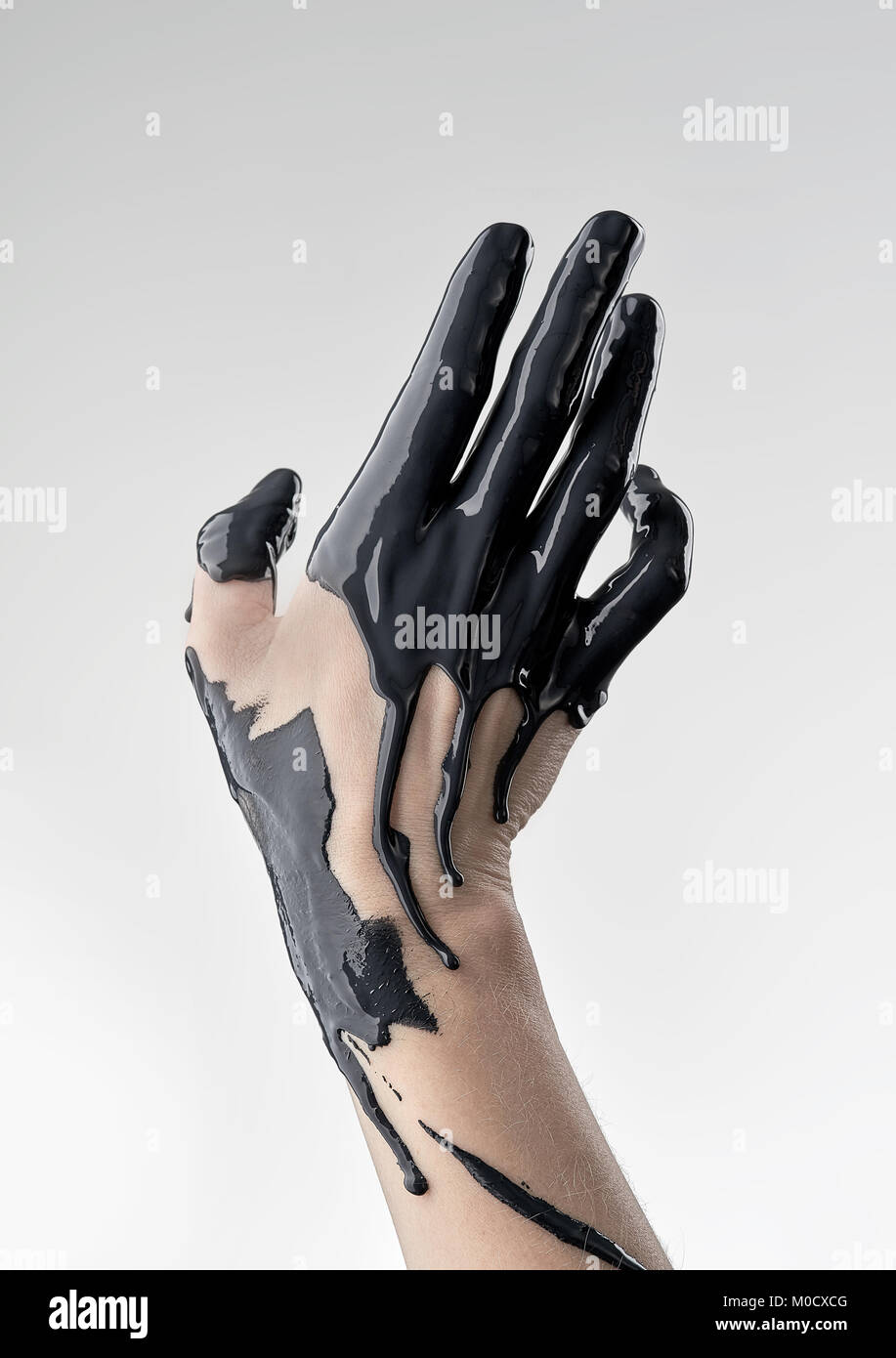 Female hand in liquid black oil or paint Stock Photo - Alamy