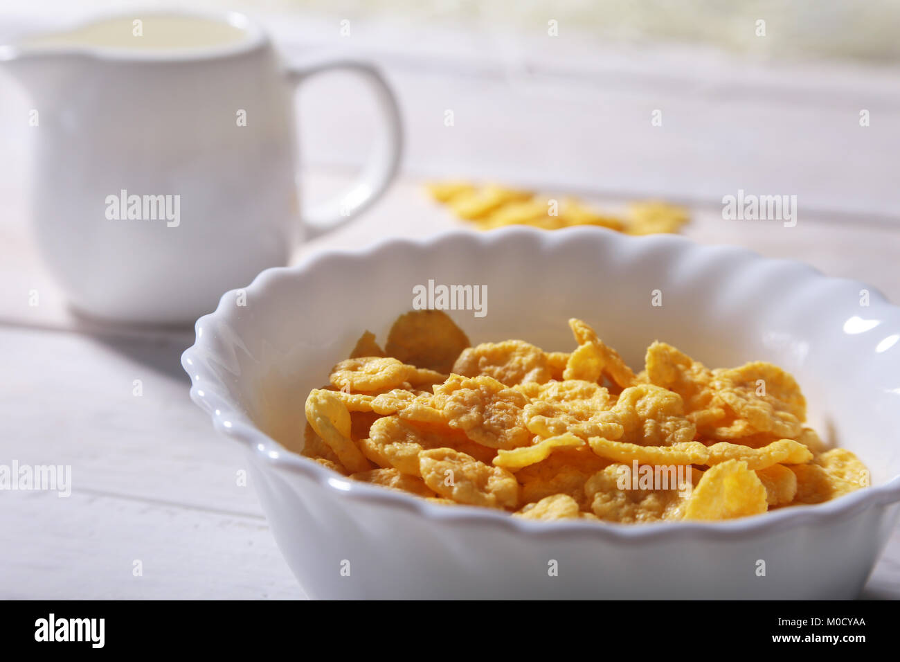 Corn Flakes cereal in a bowl and glass with milk. Morning breakfast ...