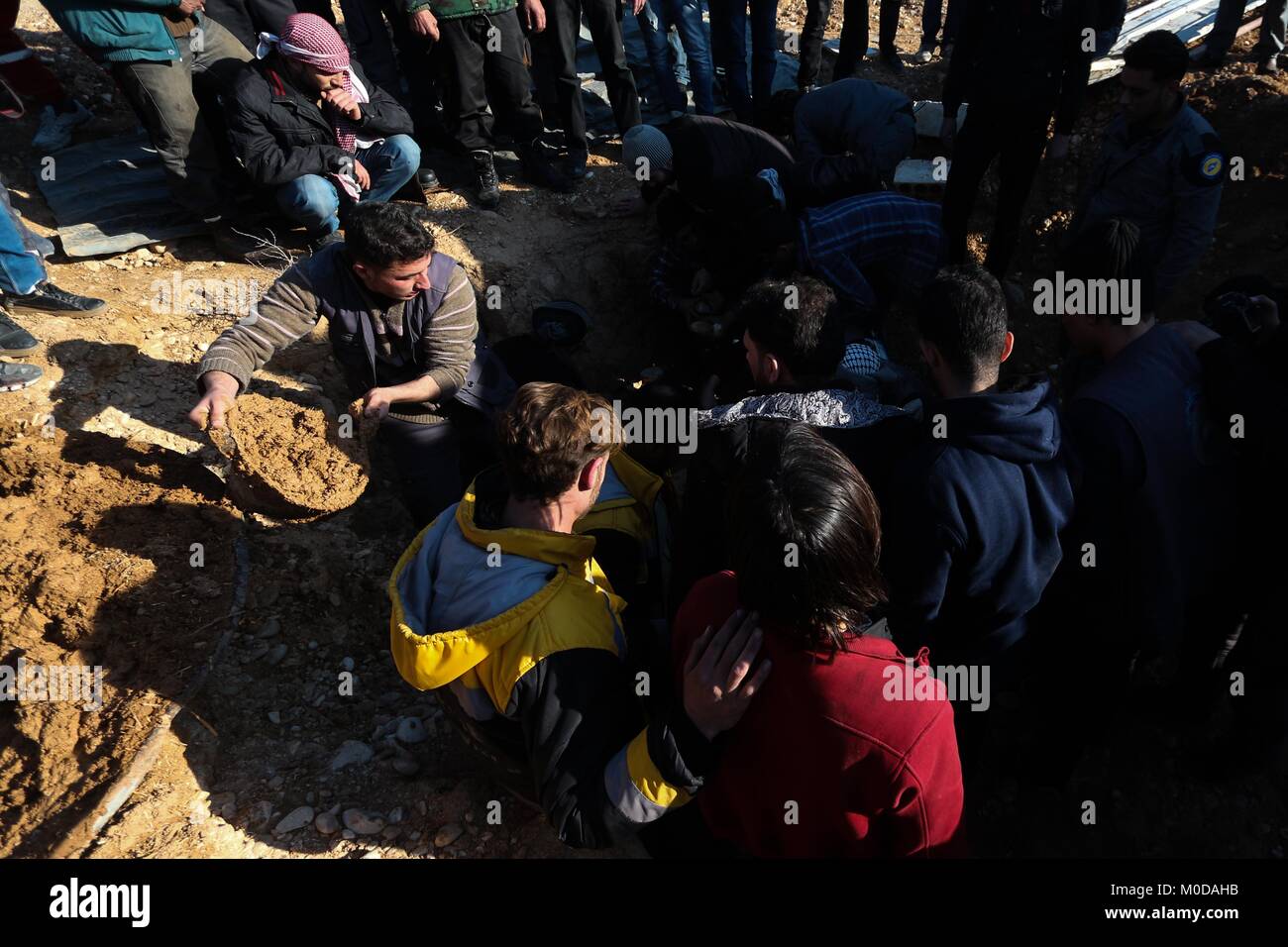 Douma, Syria. 20th Jan, 2018. White helmet seen helping people to bury ...