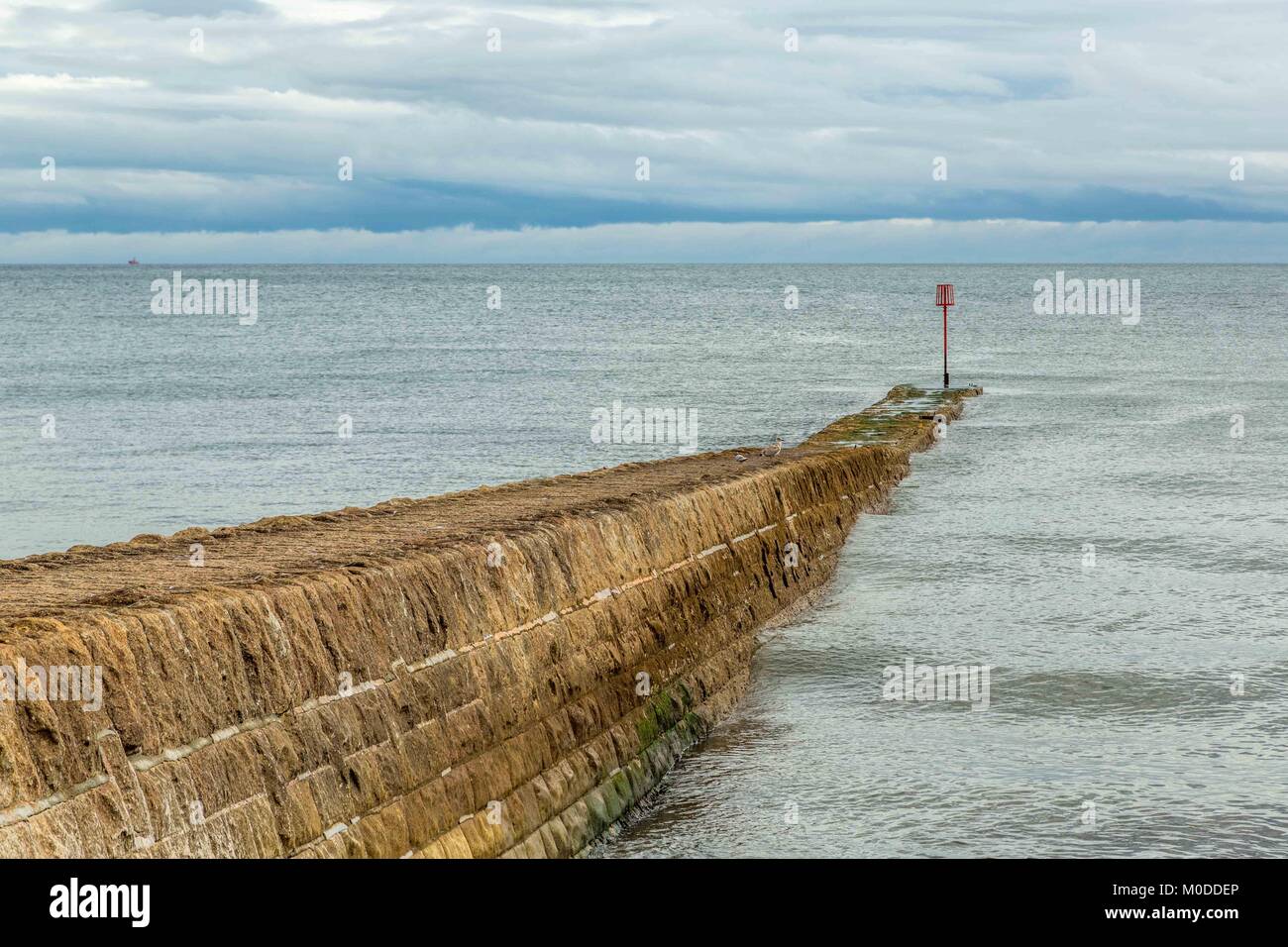 A concrete jetty stretching out to sea n the South Devon coast of ...