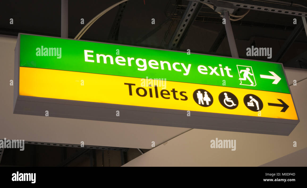 Emergency and toilets sign in an airport Stock Photo - Alamy