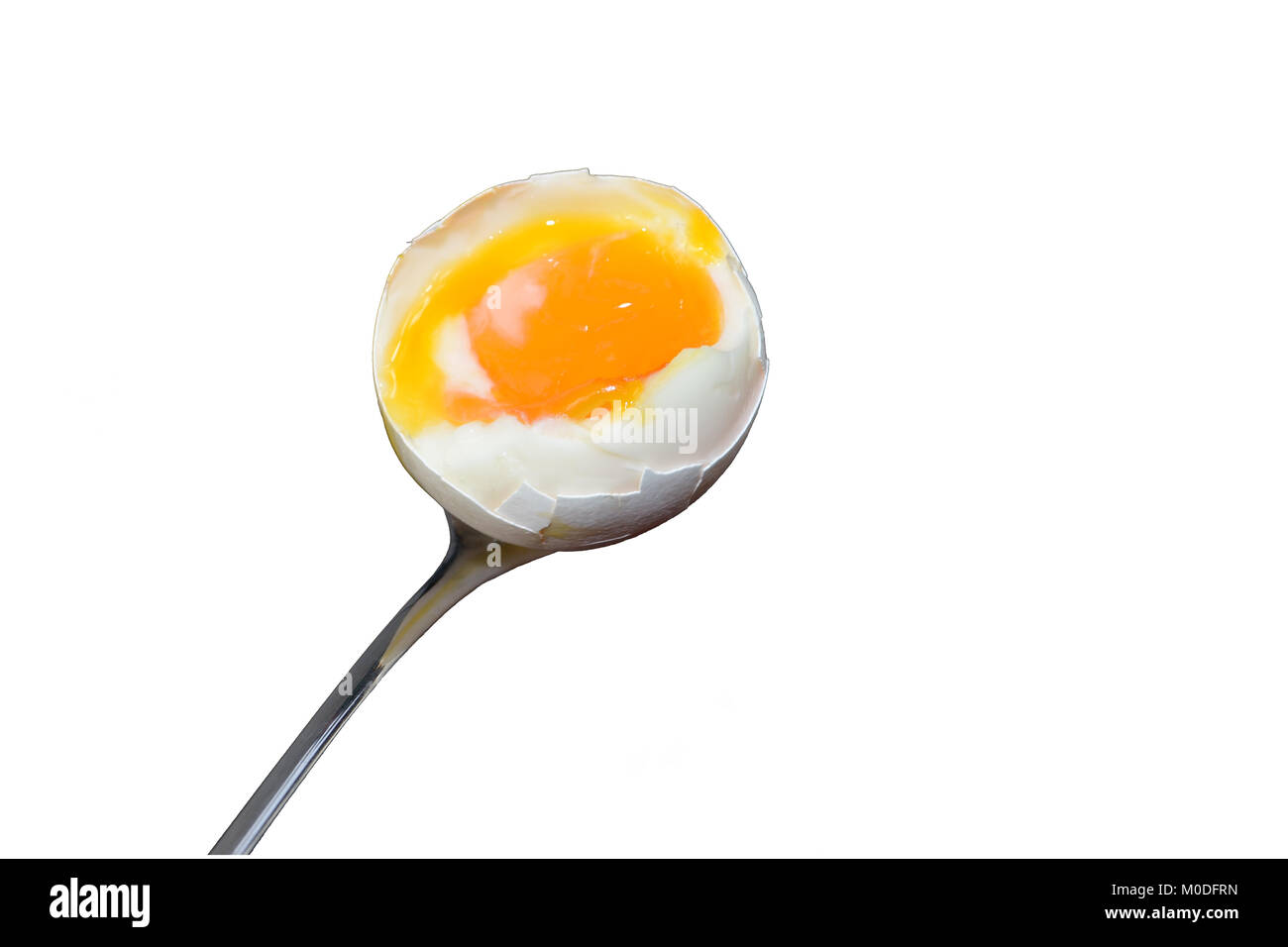 A opened, boiled egg on a silver spoon isolated on a white background ...