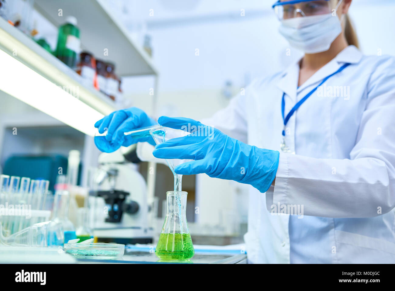 Female Scientist Pouring Liquids in Lab Stock Photo - Alamy