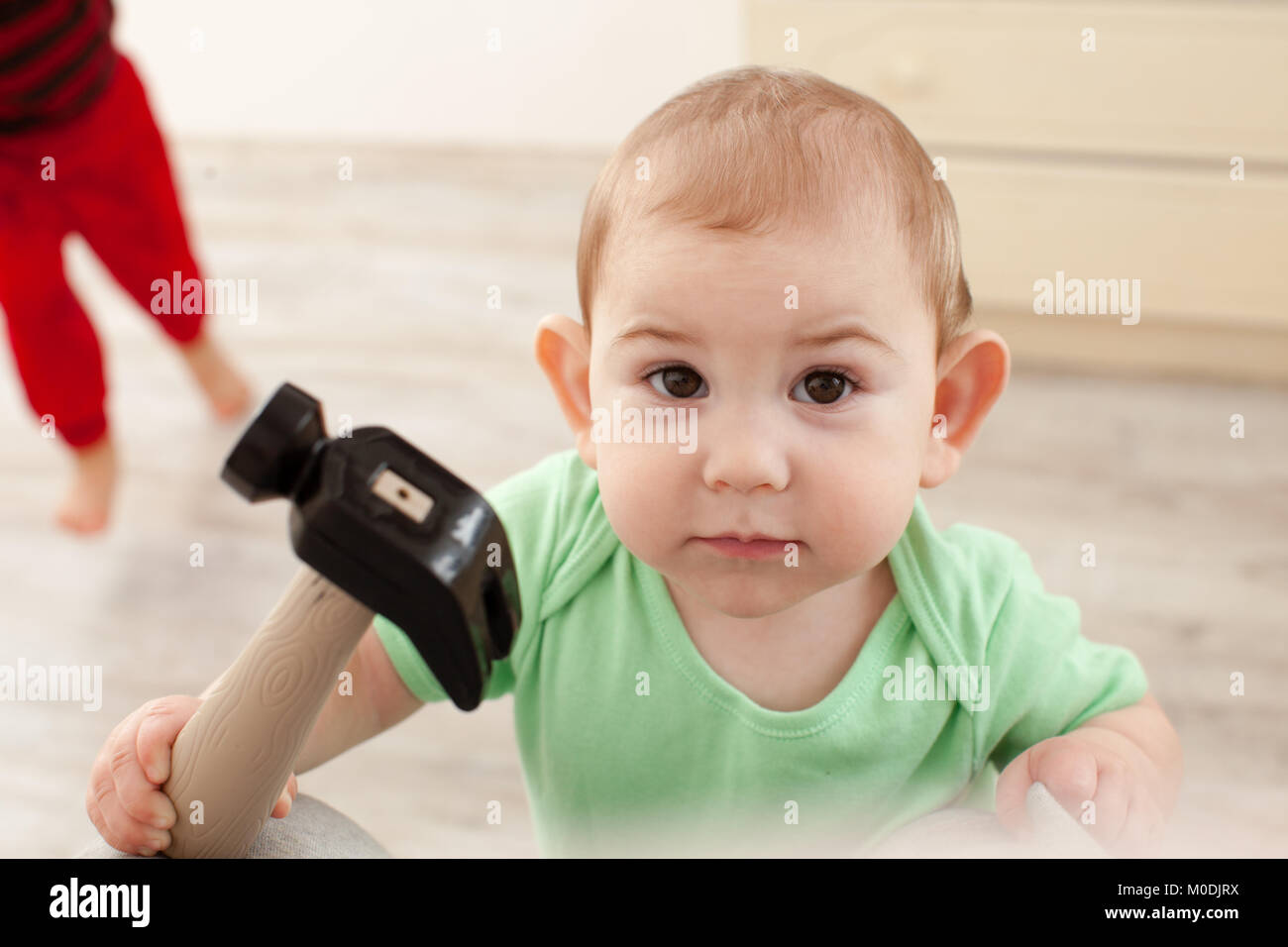 Baby with hammer intend to work Stock Photo - Alamy