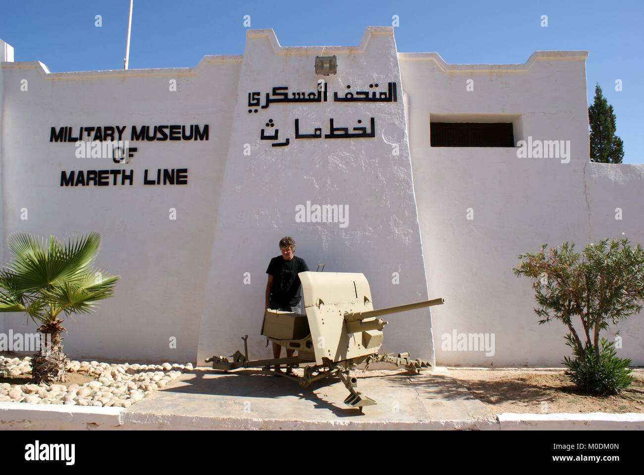 Tourist inspecting a field gun outside the Military Museum of Mareth ...