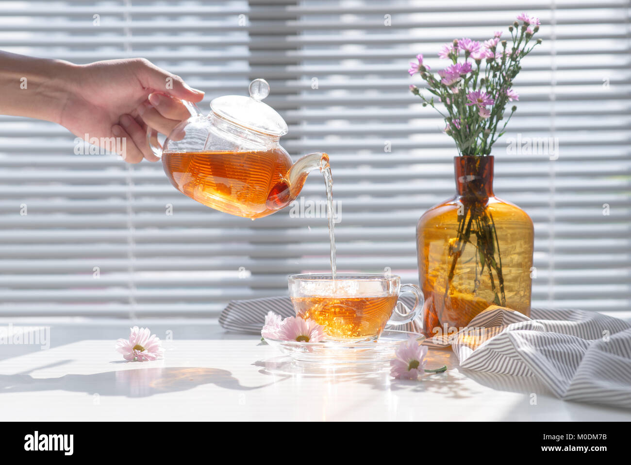 Tea being poured into glass teacup in the morning Stock Photo - Alamy