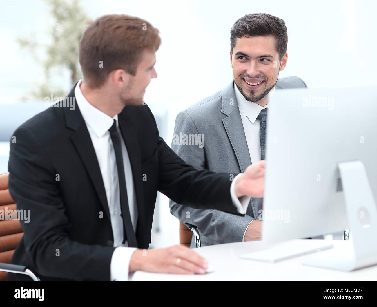 employees are talking sitting behind a Desk Stock Photo - Alamy