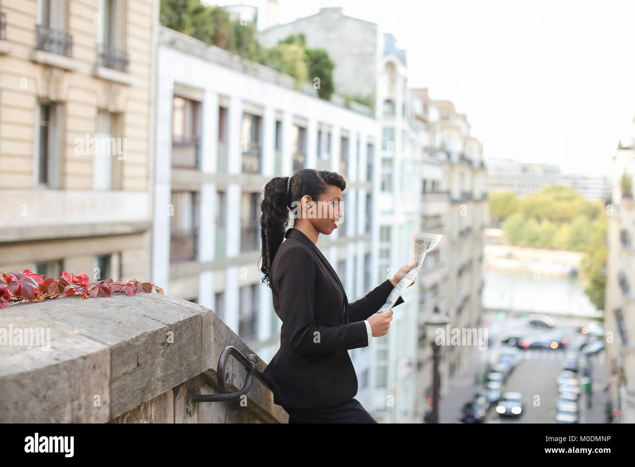 Half Nigerian reporter looking at cam with newspaper on balcony Stock ...