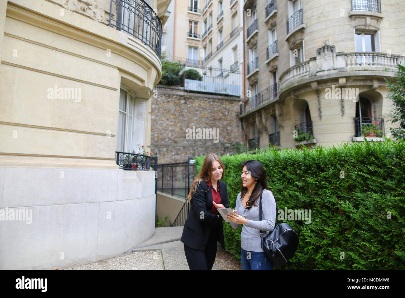 Beautiful girl talking with foreign Chinese student keeping tabl Stock ...