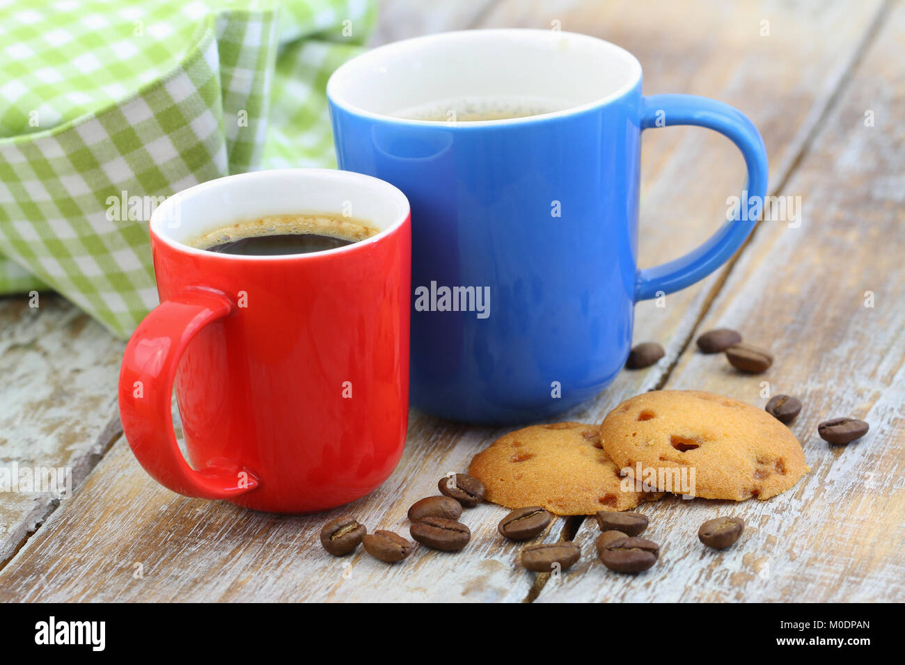 Two colorful coffee mugs and crunchy caramel biscuits on rustic wooden ...